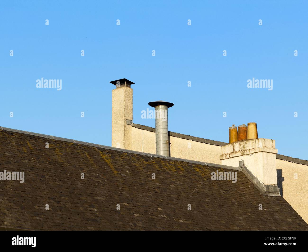 Chimney pots in a row on old building roof Stock Photo - Alamy