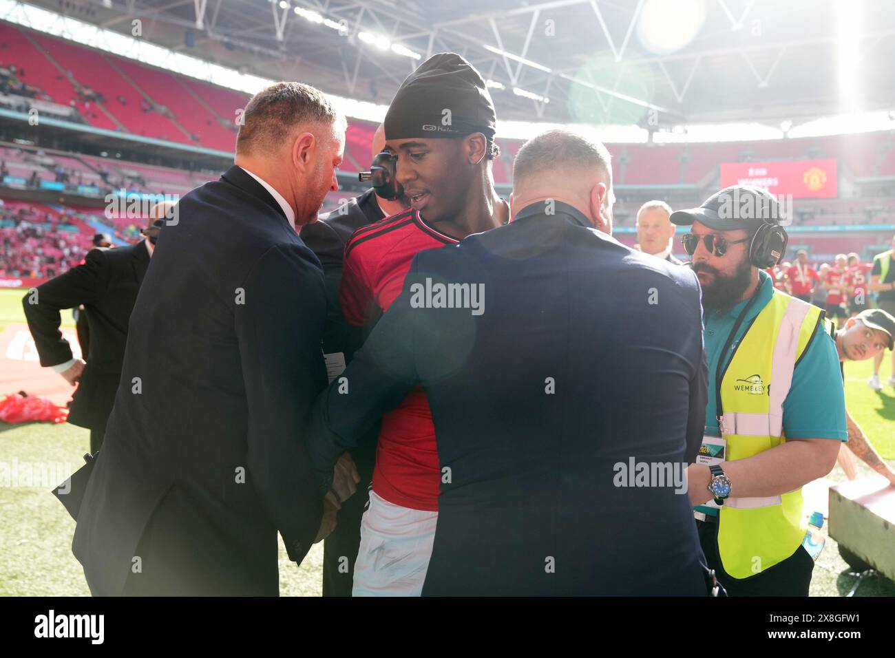 A pitch invader is apprehended by stadium security following the ...