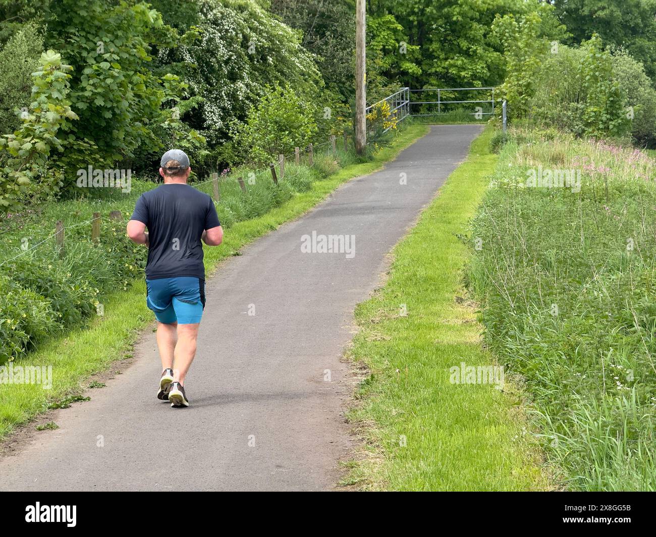 Man running on cycle path between Bridge of Weir and Kilmacolm Stock ...