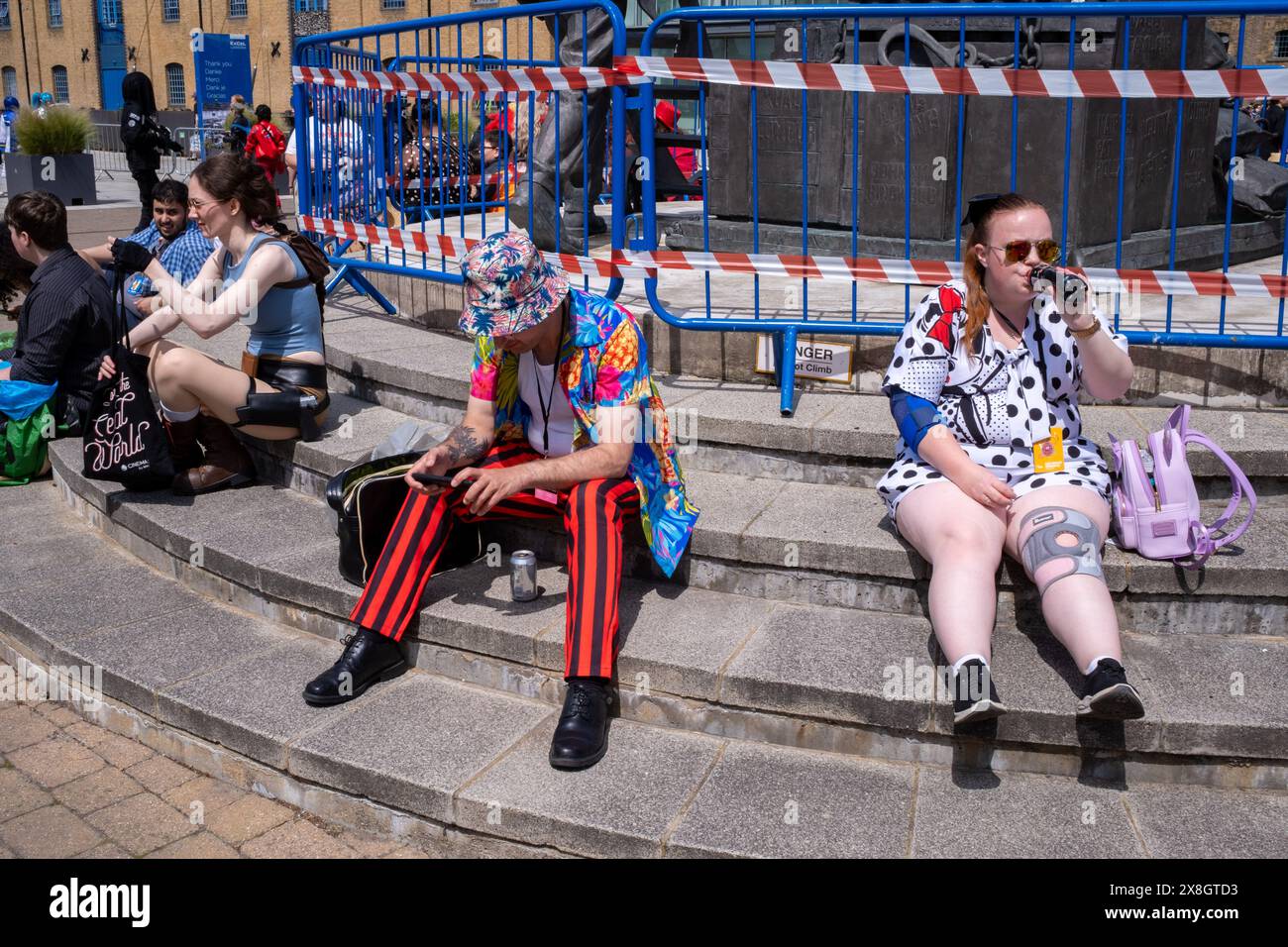 London, UK, 25th May, 2024. Visitors to day two Comic Con London sit on ...