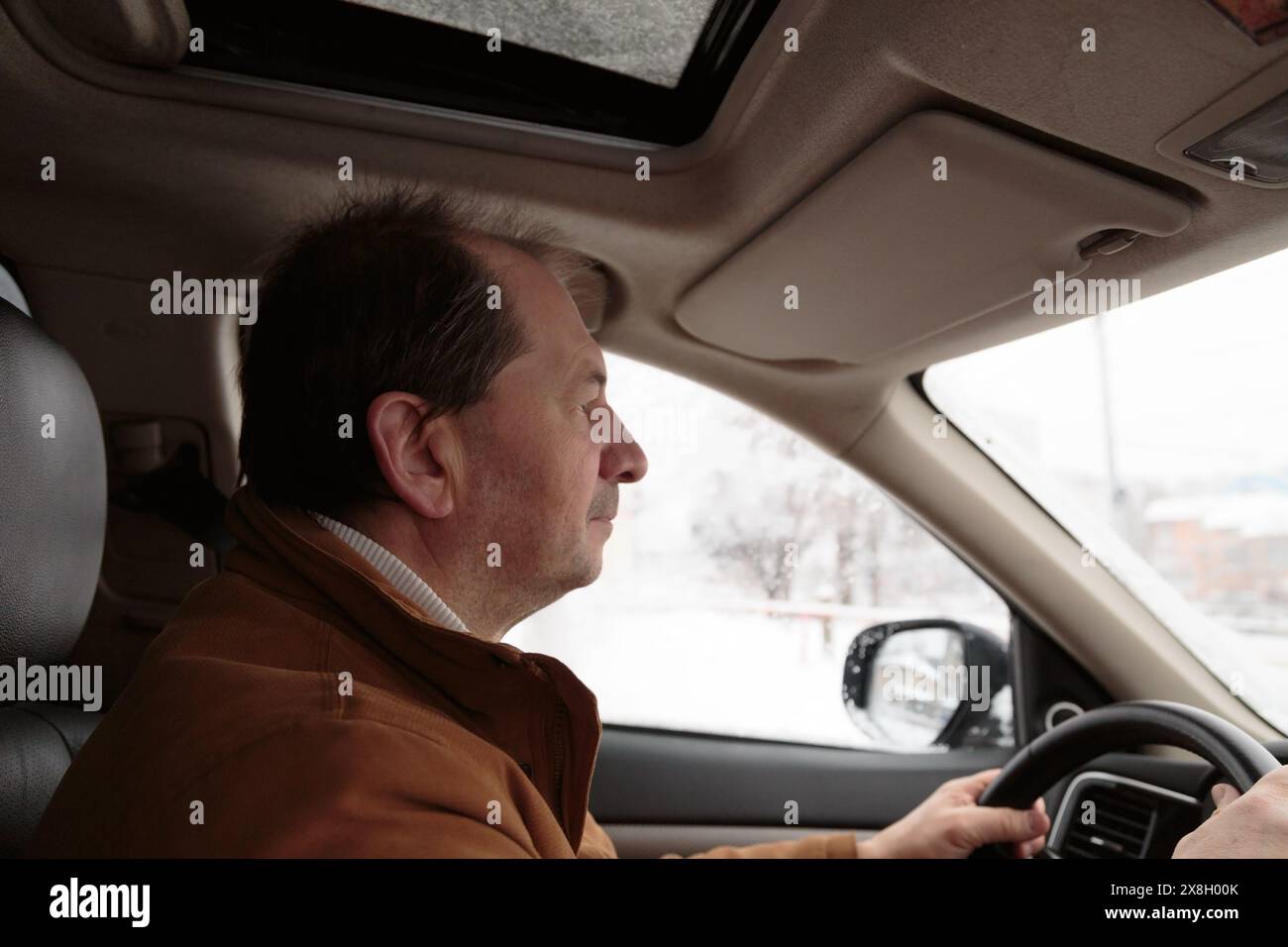 A man drives a car around the city. View from the inside of the car ...