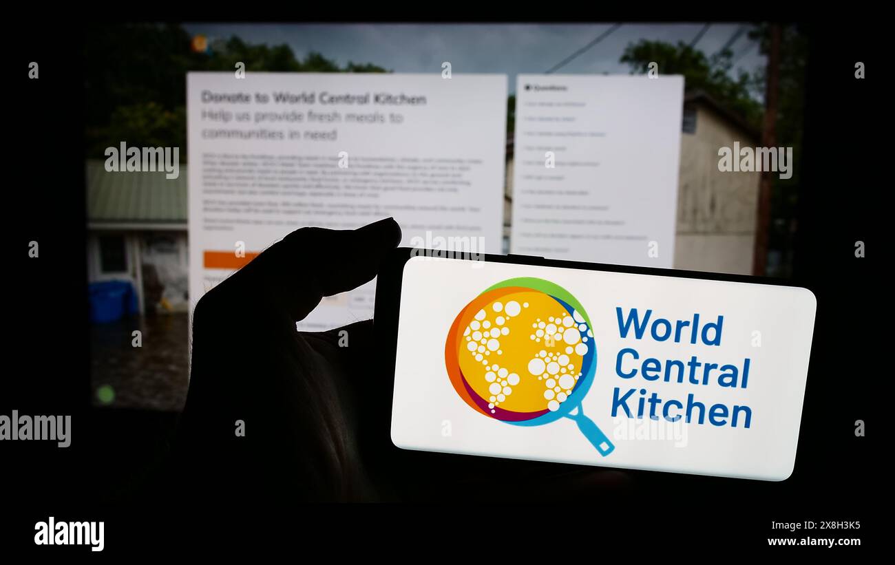 Person holding smartphone with logo of food relief organisation World ...