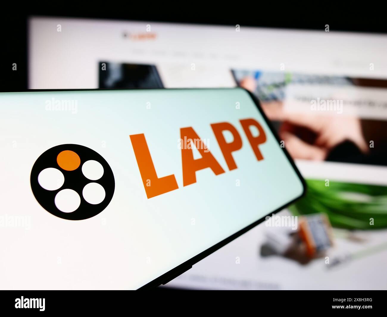 Mobile phone with logo of German cable company Lapp Holding SE in front ...