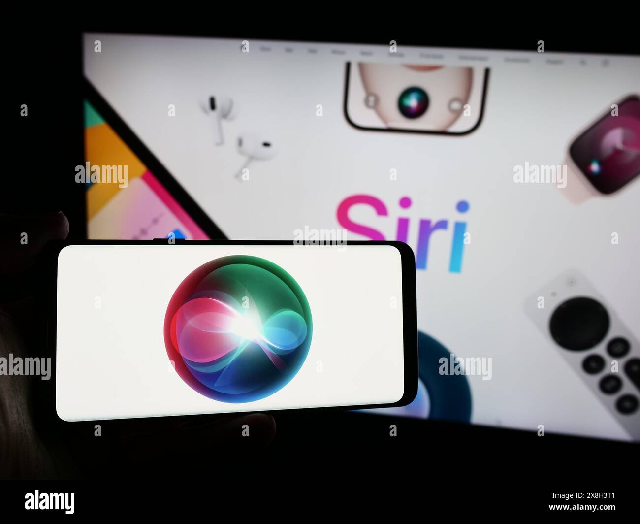 Person holding smartphone with logo of digital assistant software Siri ...