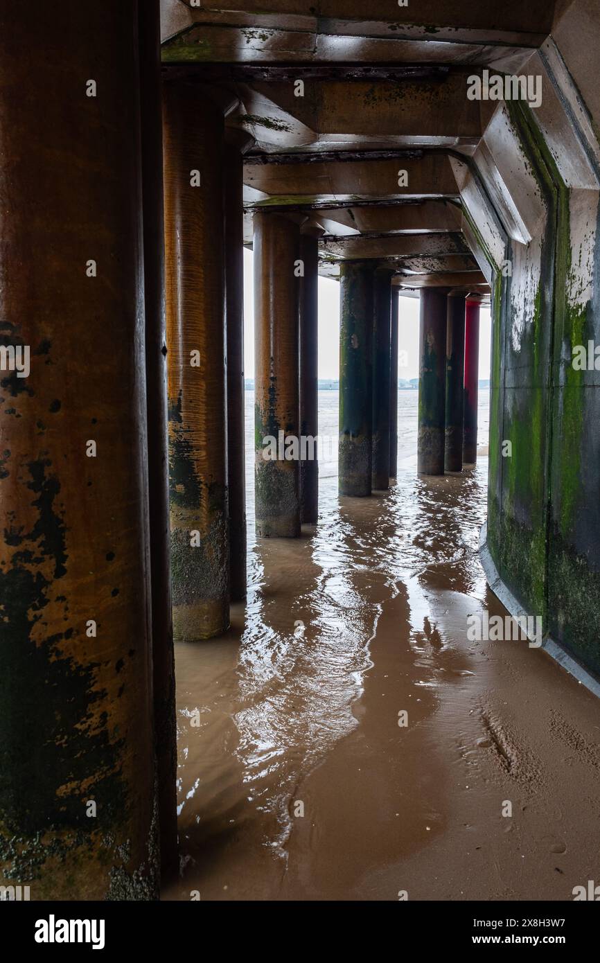 Rusty metal pillars under pier with waves highlighting texture and ...
