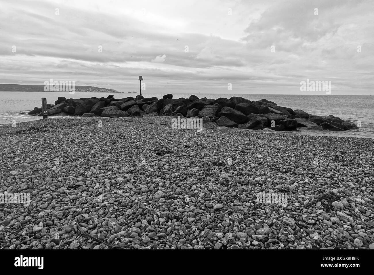 A monochrome photograph of a rocky breakwater which overlooks the Isle ...