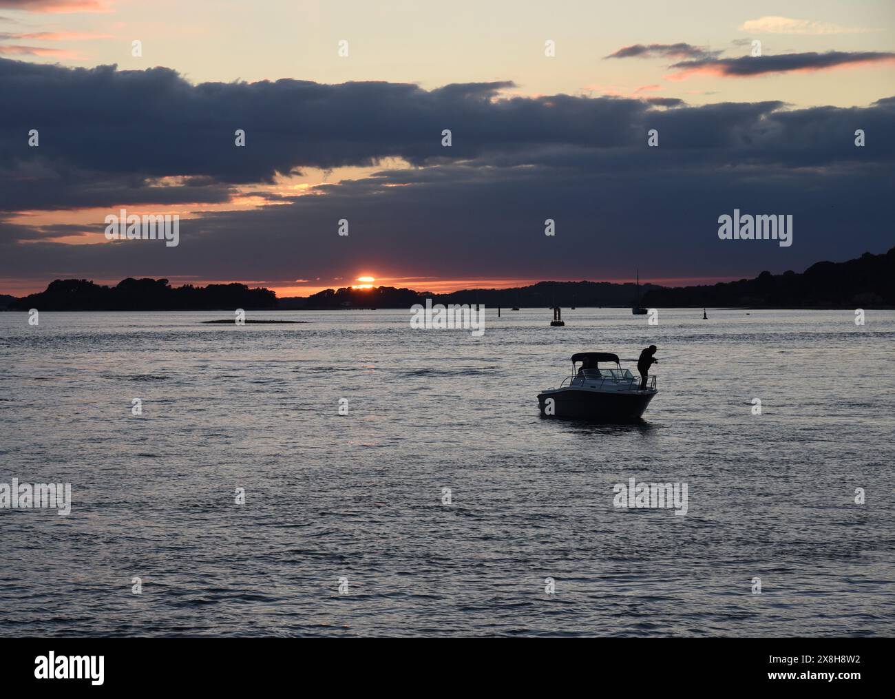 Photograph of a fishing boat at sunset in Poole Harbour Stock Photo - Alamy