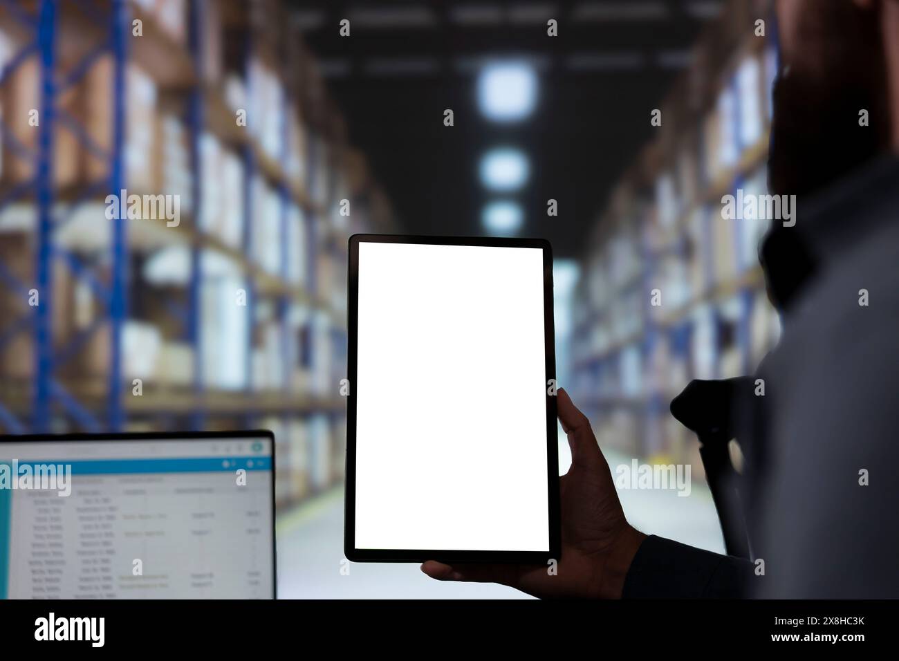 Industrial advisor shows display with white screen in storehouse ...