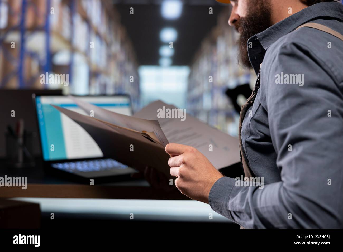 Depot manager checking stock inventory on archived documents, reviewing ...