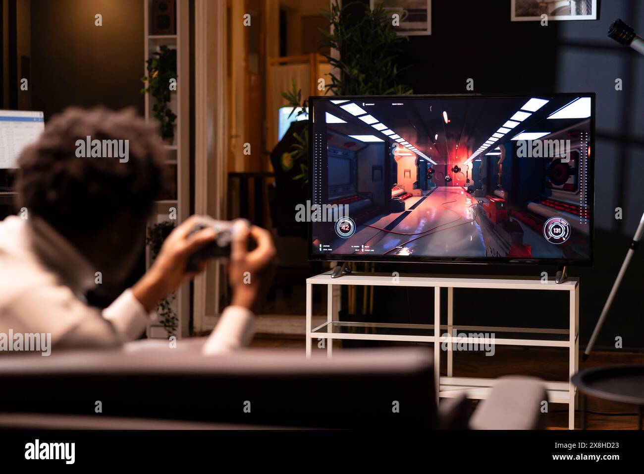 Gamer using controller to play first person shooter videogame on smart ...