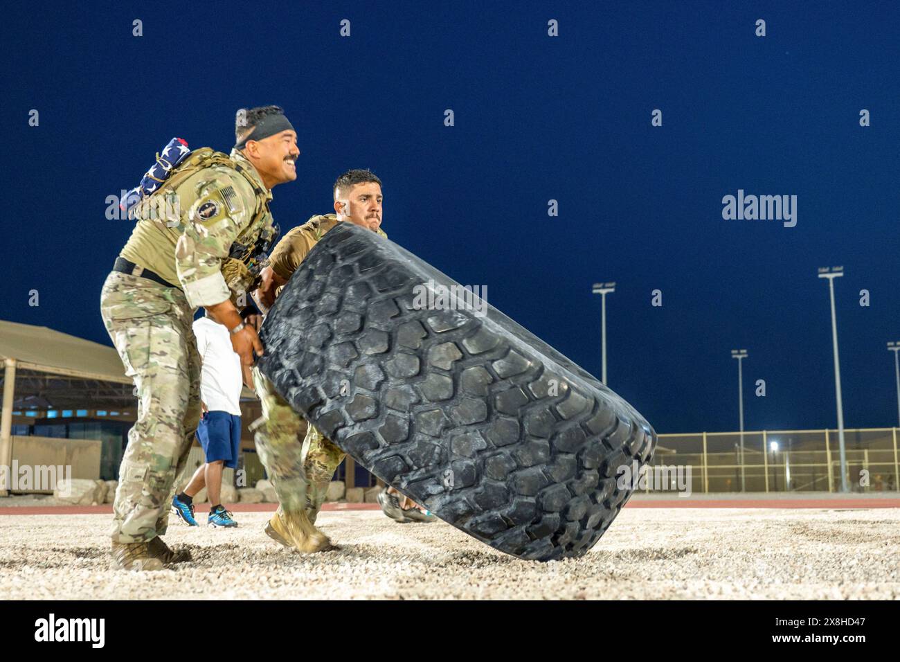 Airmen assigned to the 379th Air Expeditionary Wing flip a tire during ...