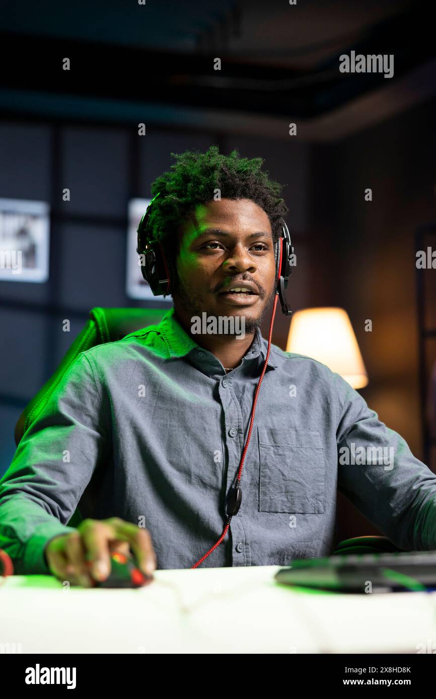 Green neon light shining on cheerful gamer face engaging in online ...