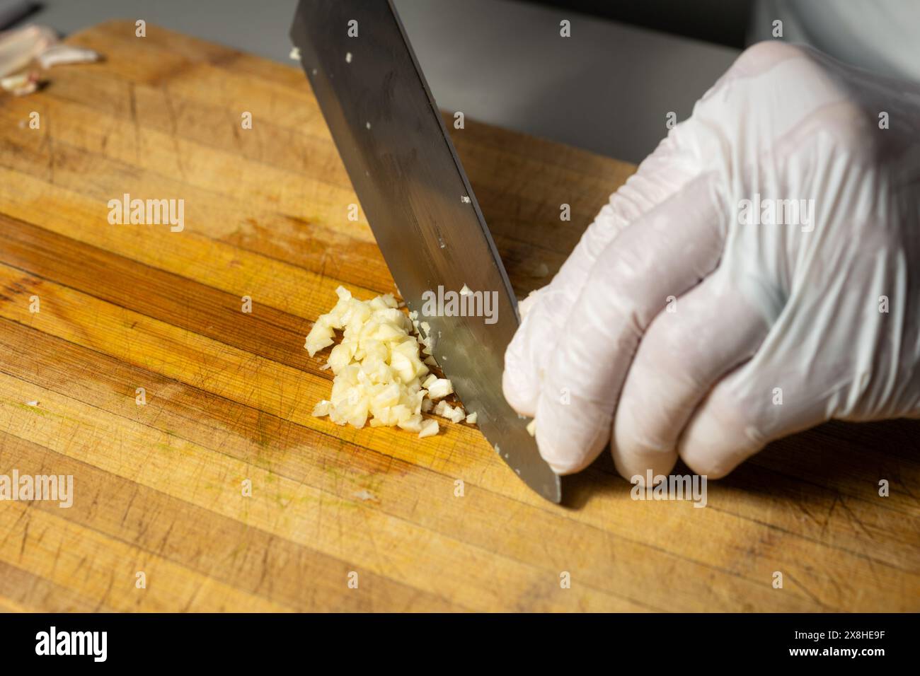 Chef dicing garlic with a cook's knife. Studio shot Stock Photo - Alamy
