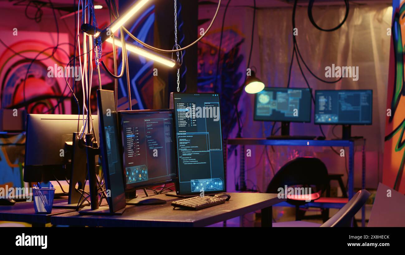 Programming language on PC screens in empty messy hackers base of ...