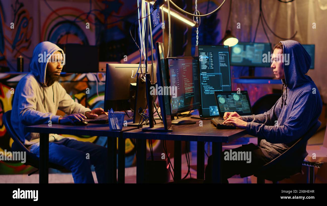 Hacker Group Members Working Together In Hidden Place With Graffiti Walls Deploying Malware On