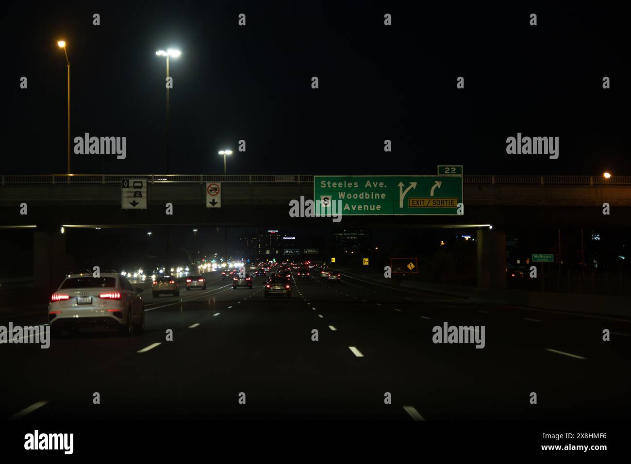 Nighttime highway with vehicles in motion illuminated by streetlights ...