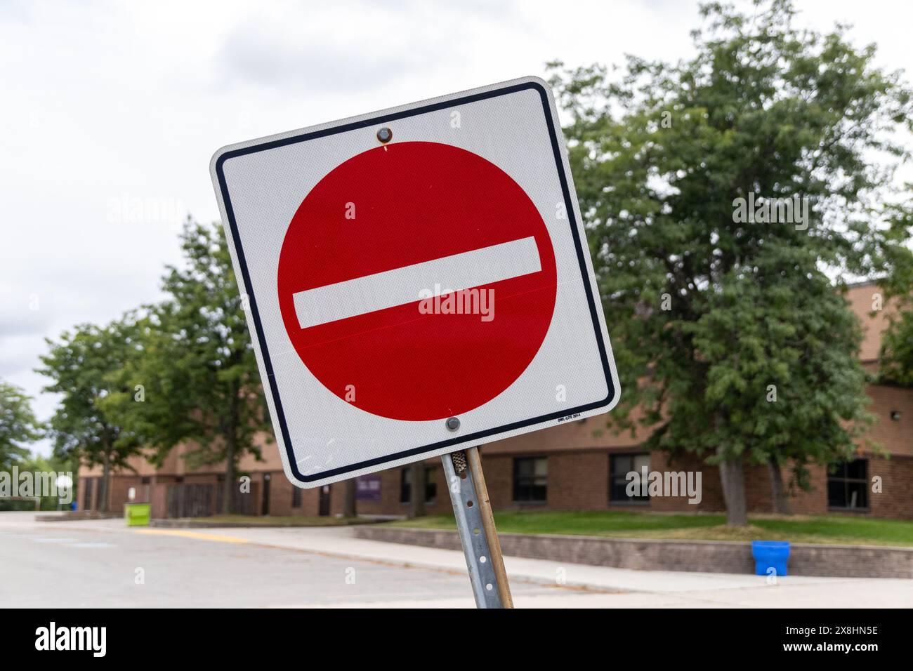 Red and white No Entry sign - school building and green trees - cloudy ...