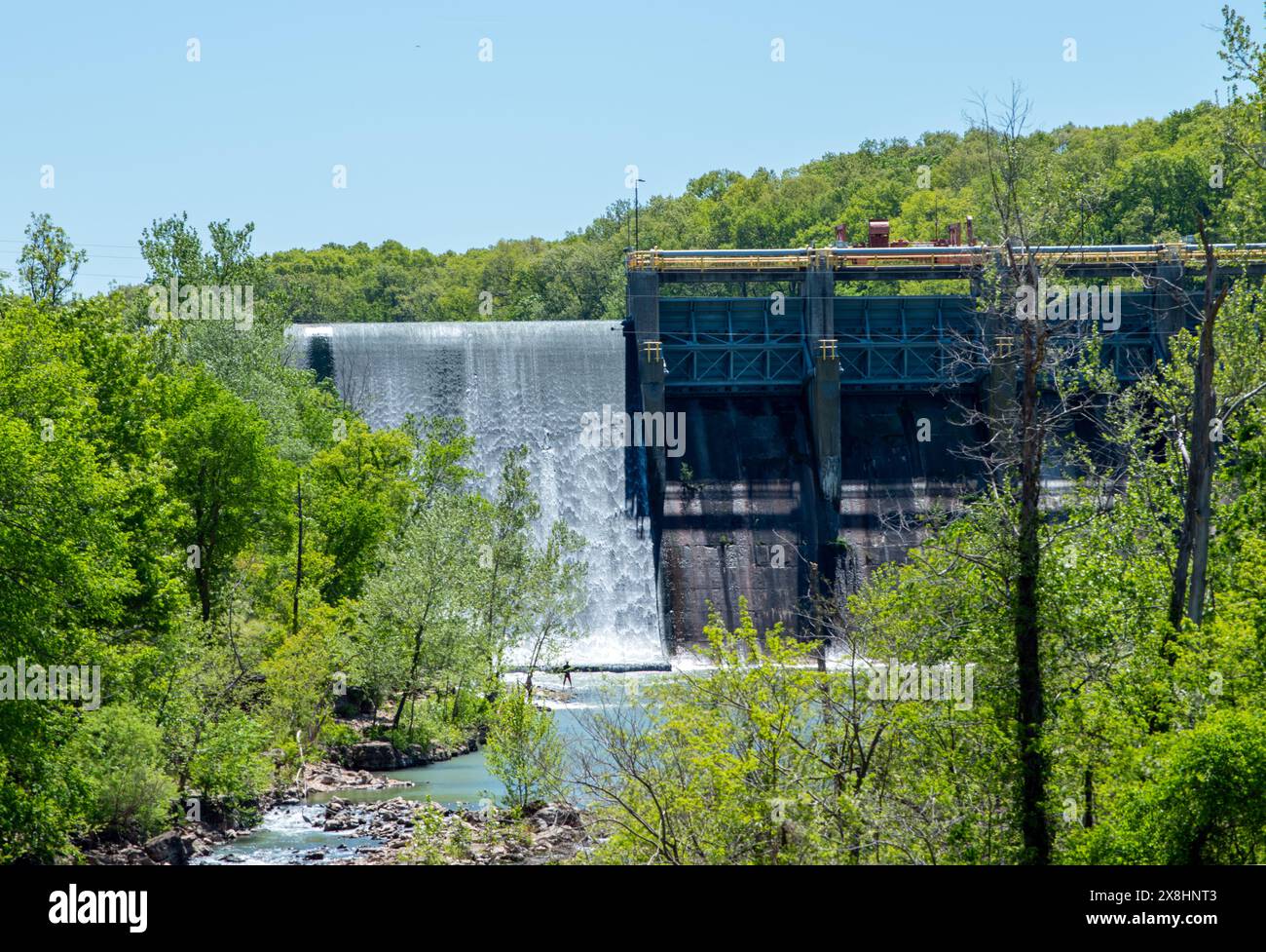 Water cascades smoothly and gracefully over a dam in Oklahoma on a warm ...