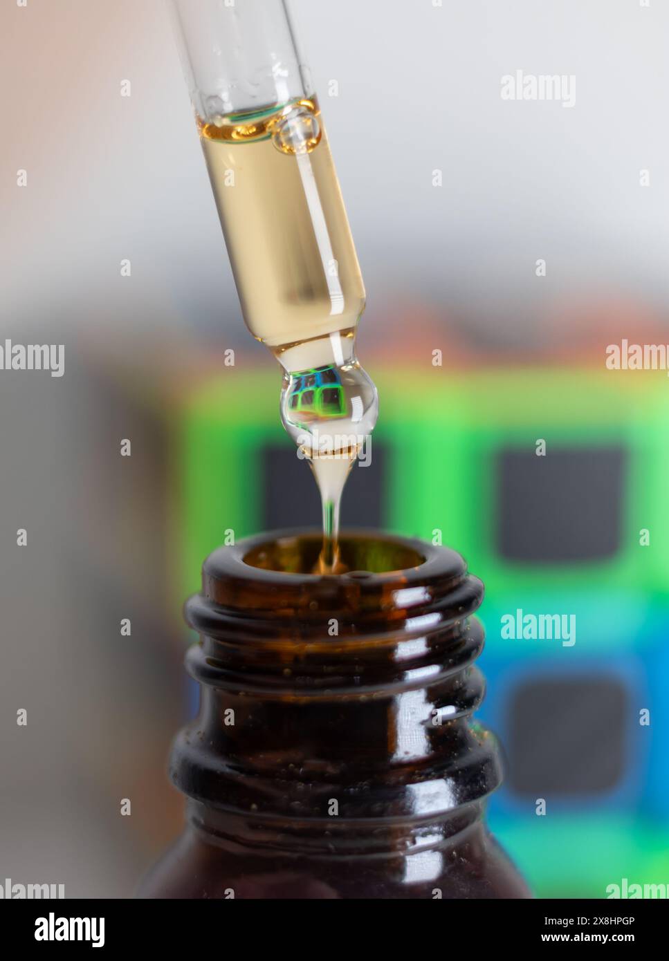 Close-Up Of Dropper With Liquid Over Brown Bottle. A close-up image ...
