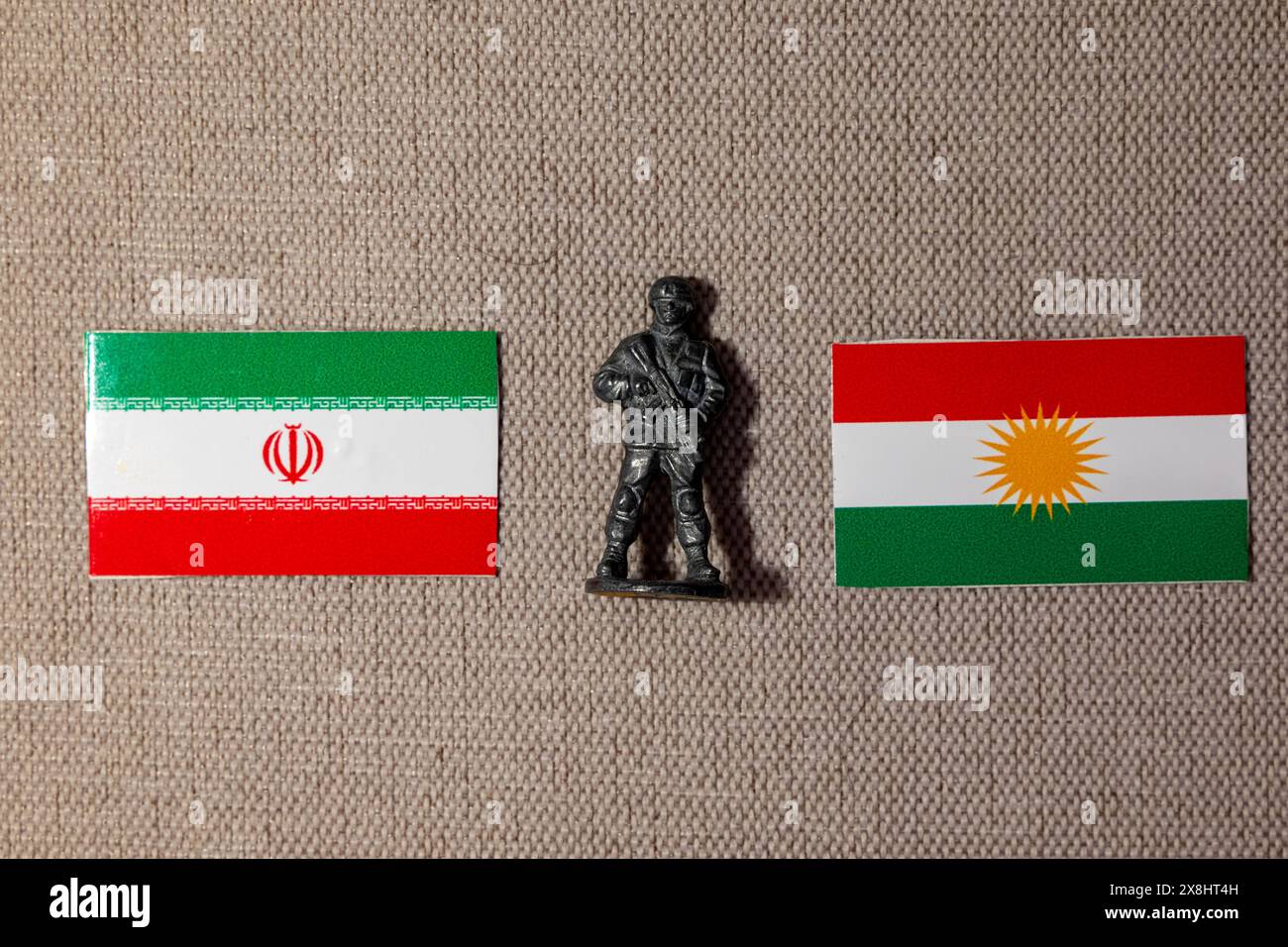 A soldier figurine on the background of the flags of Iran and Kurdistan ...