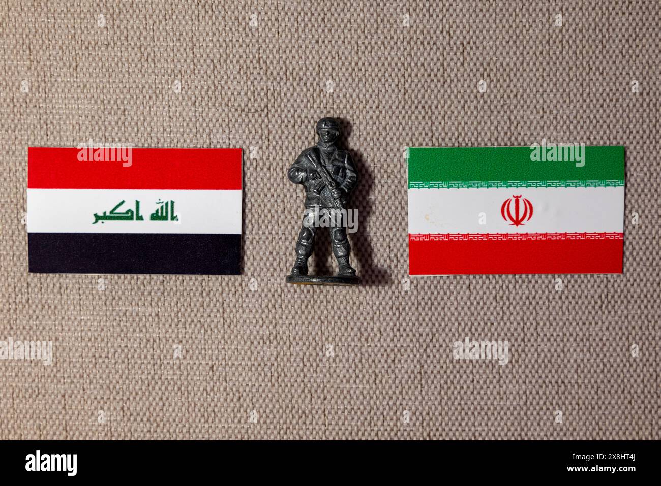 A soldier figurine on the background of the flags of Iran and Iraq ...
