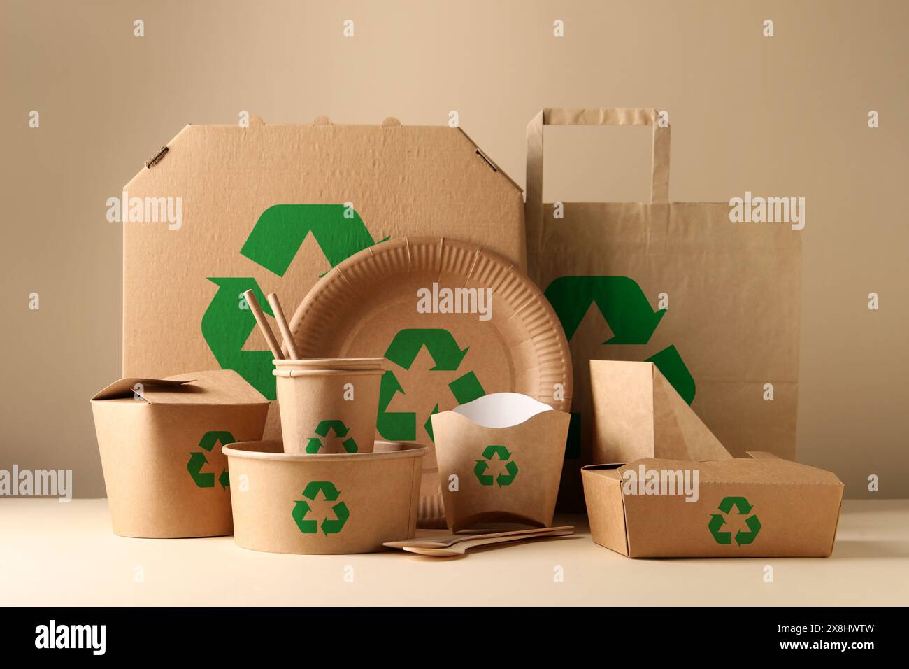 Set of eco friendly food packaging with recycling symbols on table ...