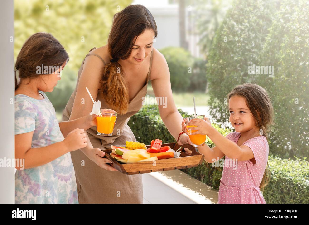 Mom gives kids healthy snack from tray in backyard on vacation Stock ...