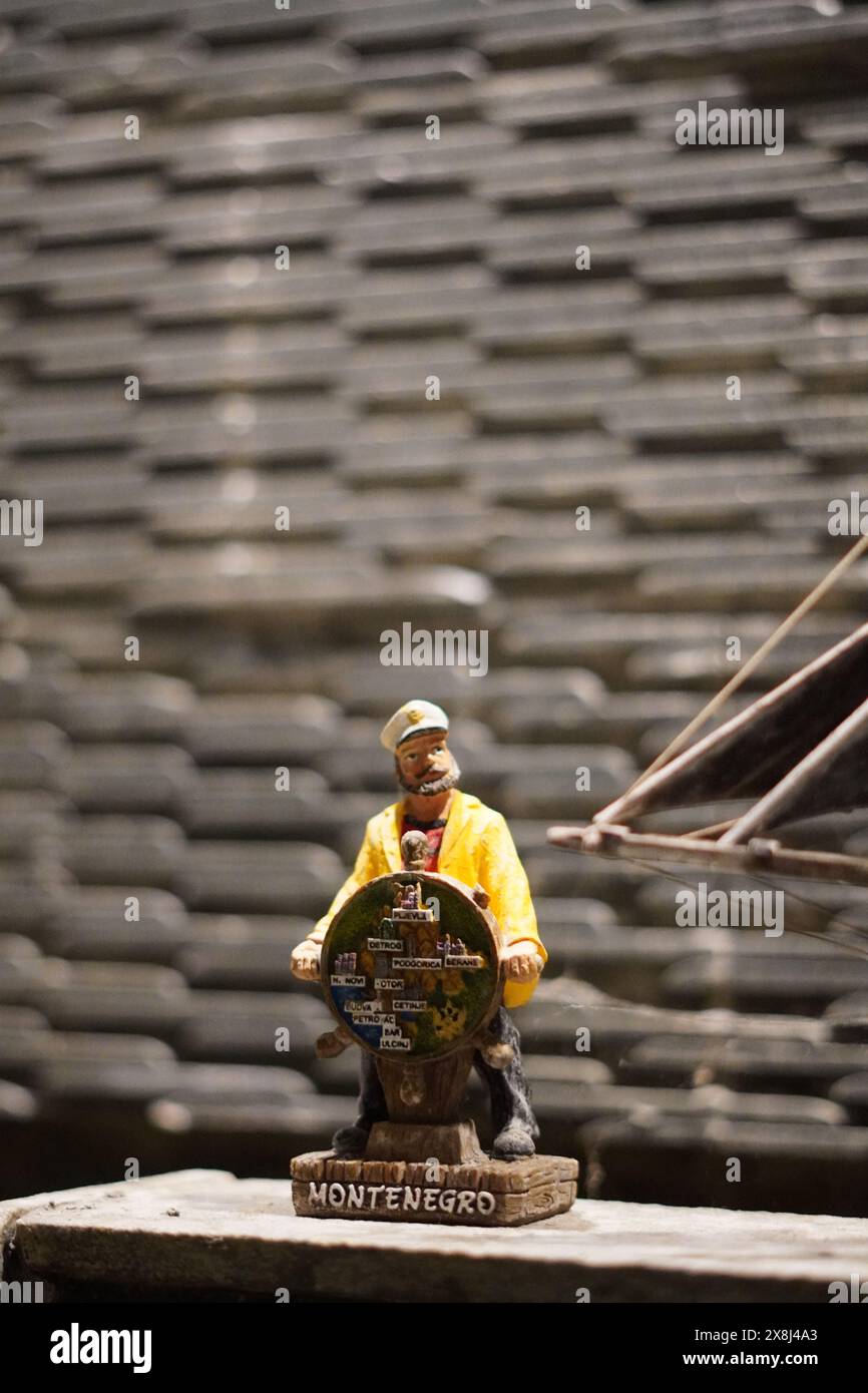 Figure of a sailor holding the steering wheel of a ship with the words ...