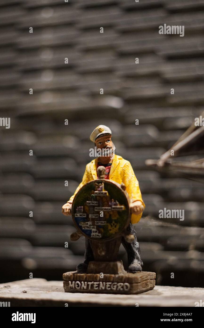 Figure of a sailor holding the steering wheel of a ship with the words ...