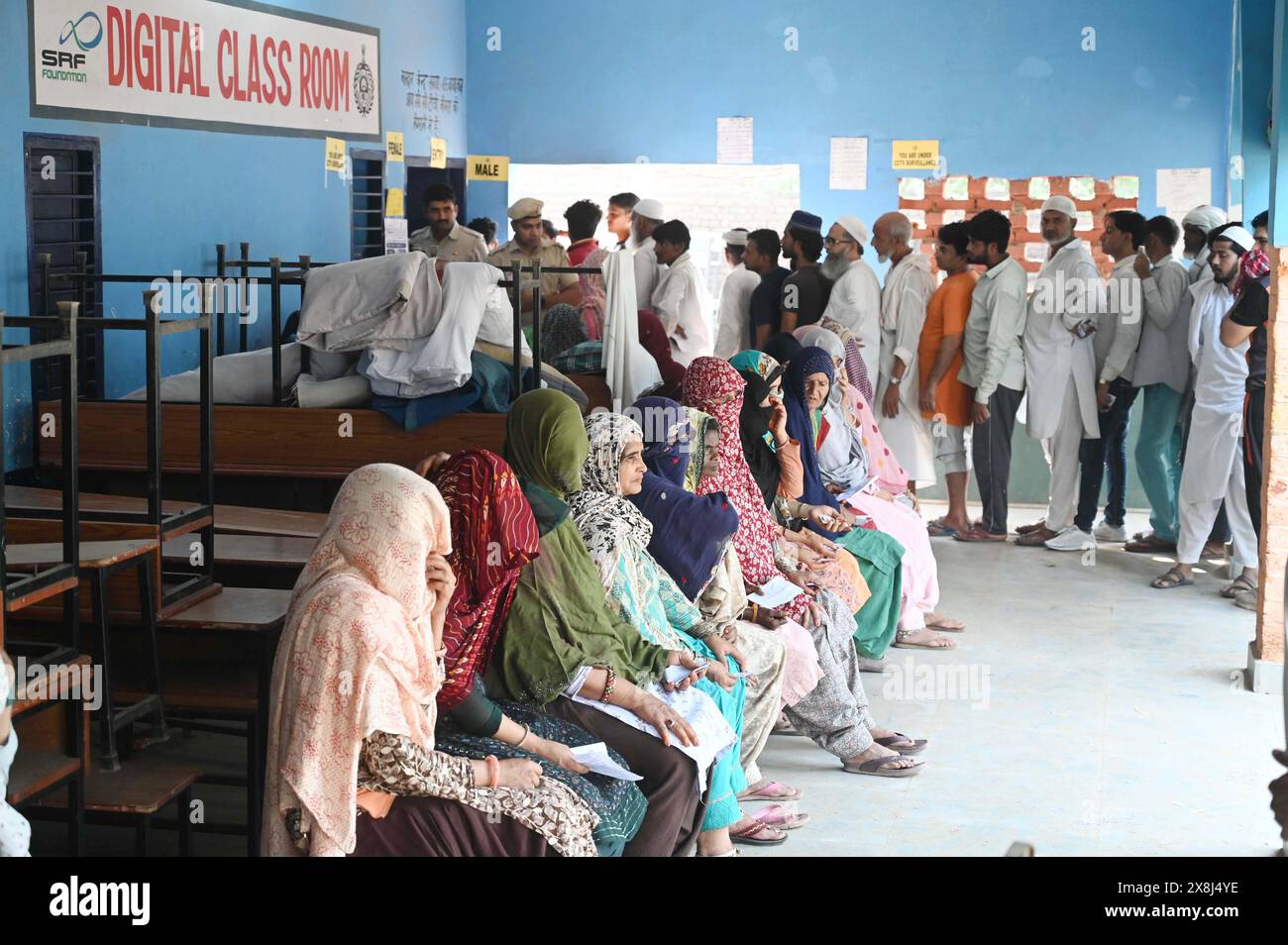 GURUGRAM, INDIA - MAY 25: Voters wait outside a polling booth to cast ...