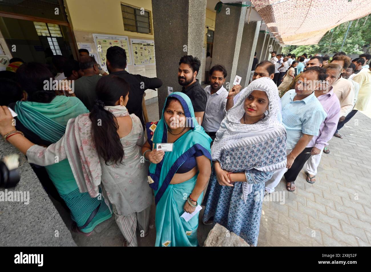 NEW DELHI, INDIA - MAY 25: People queue up inside a polling booth to ...