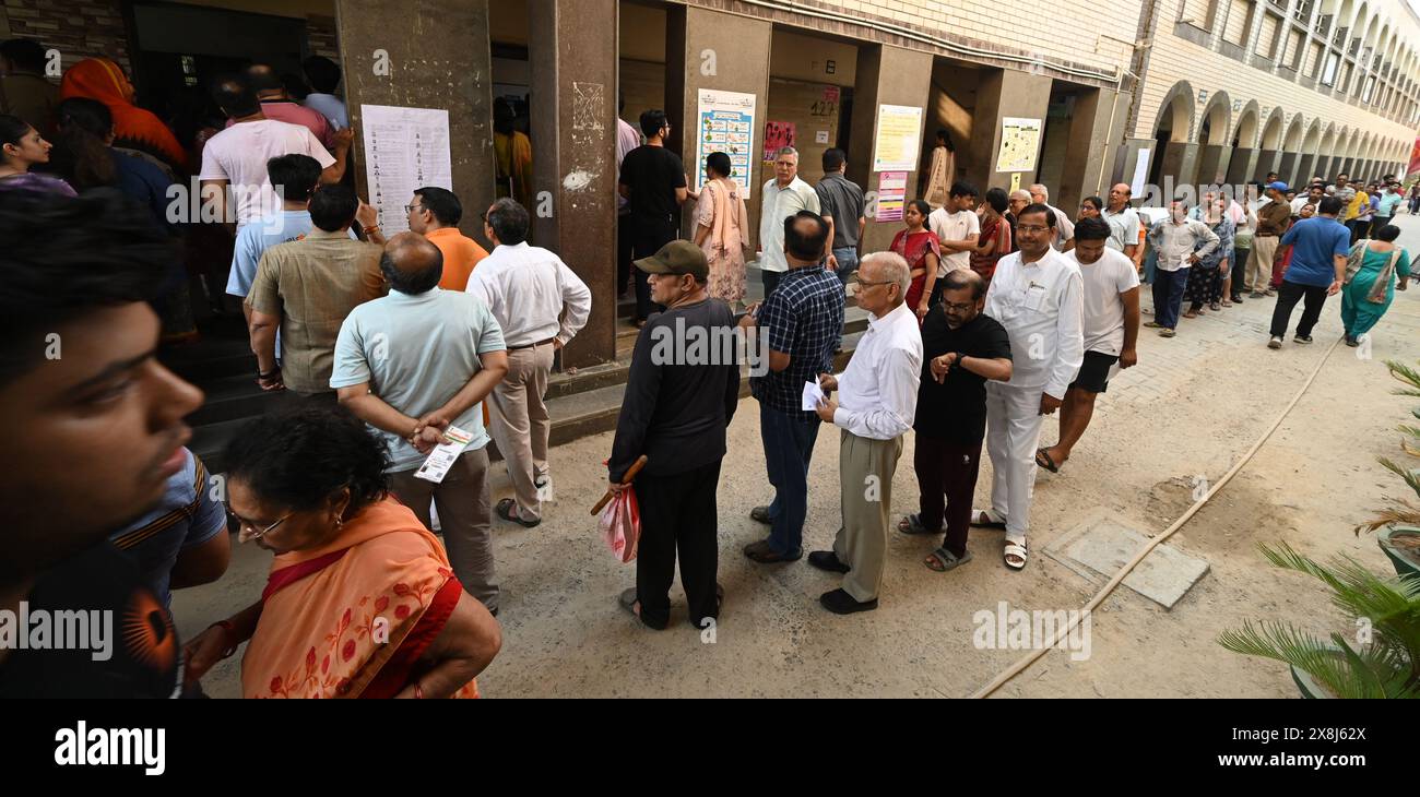 NEW DELHI, INDIA - MAY 25: Voters stand in queue to cast their votes at ...