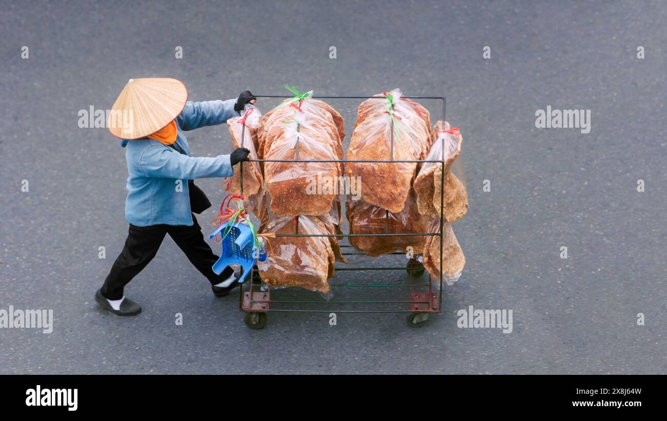 Aerial view of a Vietnamese street vendor pulls a cart with food along ...