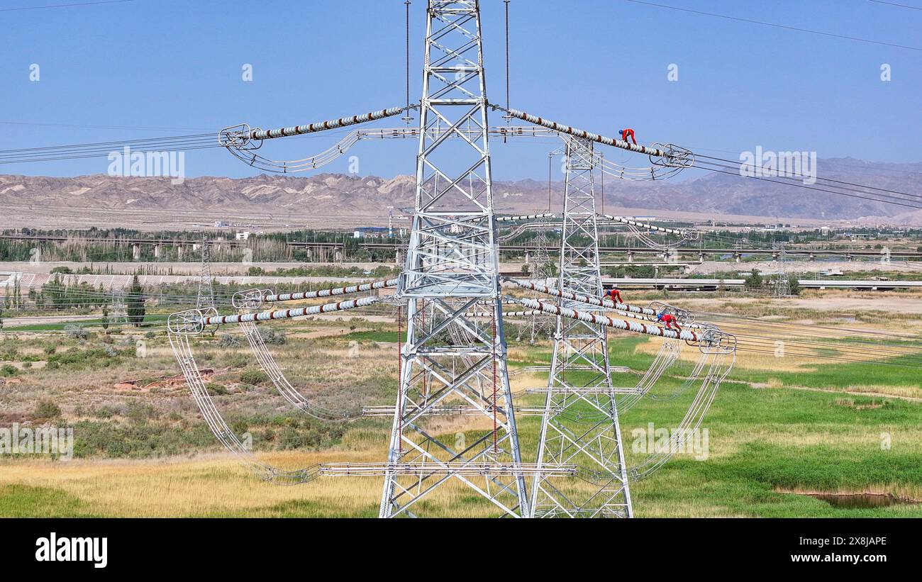 KORLA, CHINA - MAY 23, 2024 - Construction workers erect a power grid ...