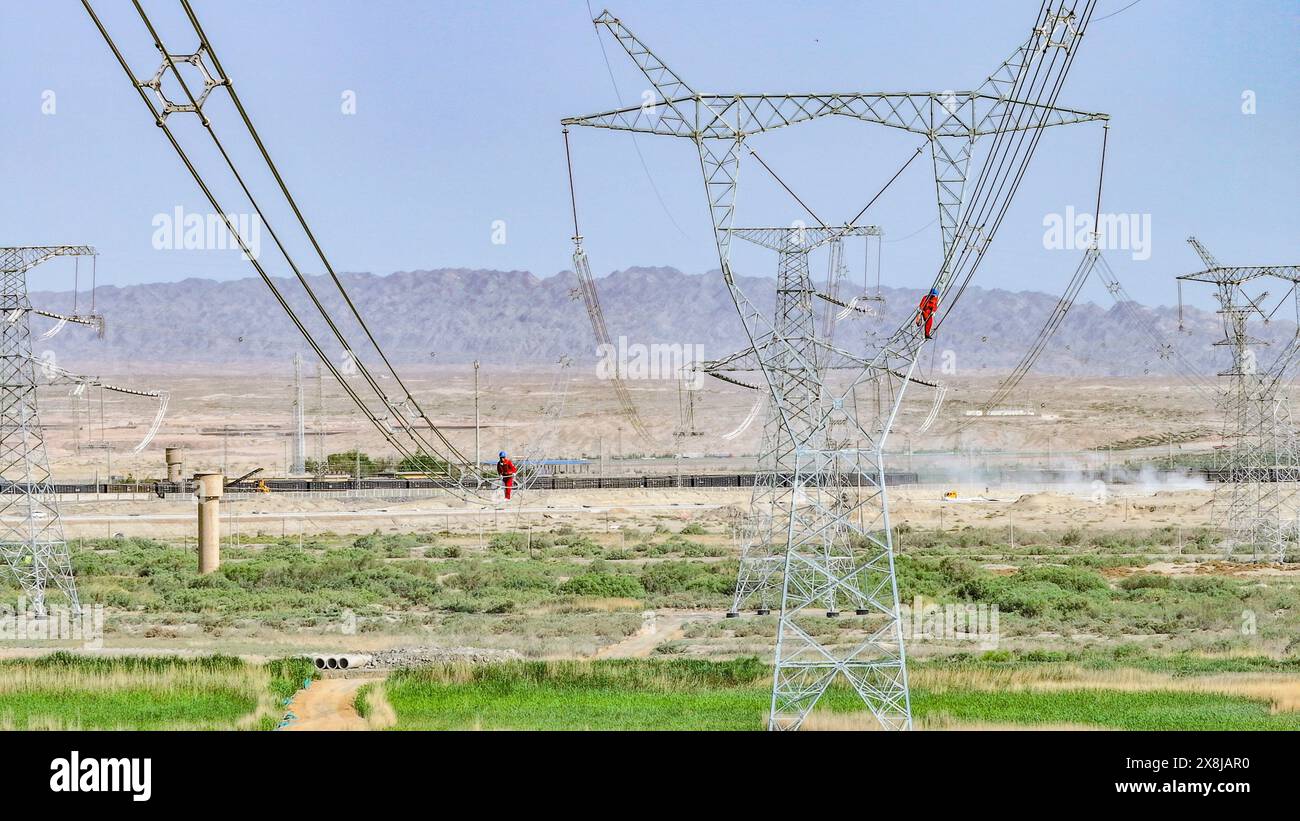 KORLA, CHINA - MAY 23, 2024 - Construction workers erect a power grid ...