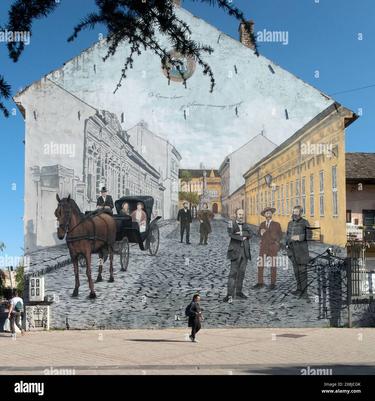 young woman walking along the mural "From Serbian Athens... to the ...