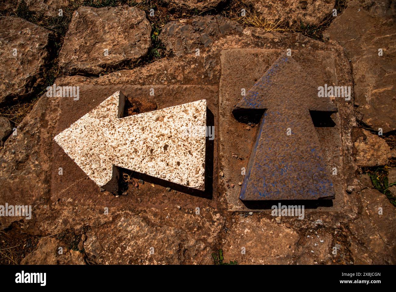 arrow carved in marble on brown ground white color direction indication ...