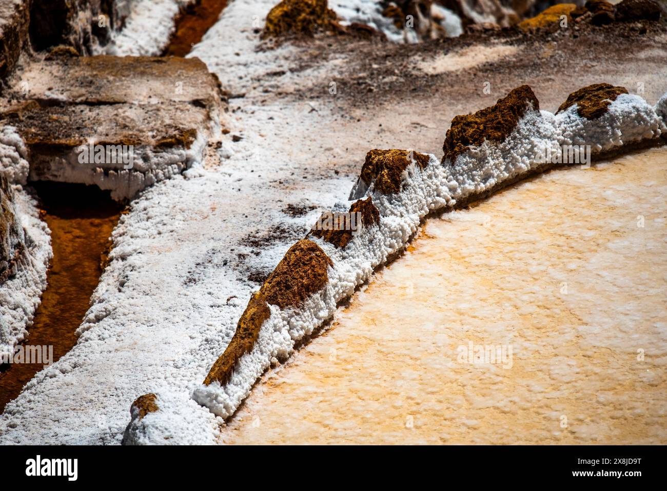 detail of the mountain salt pans with the white of the salt and the ...