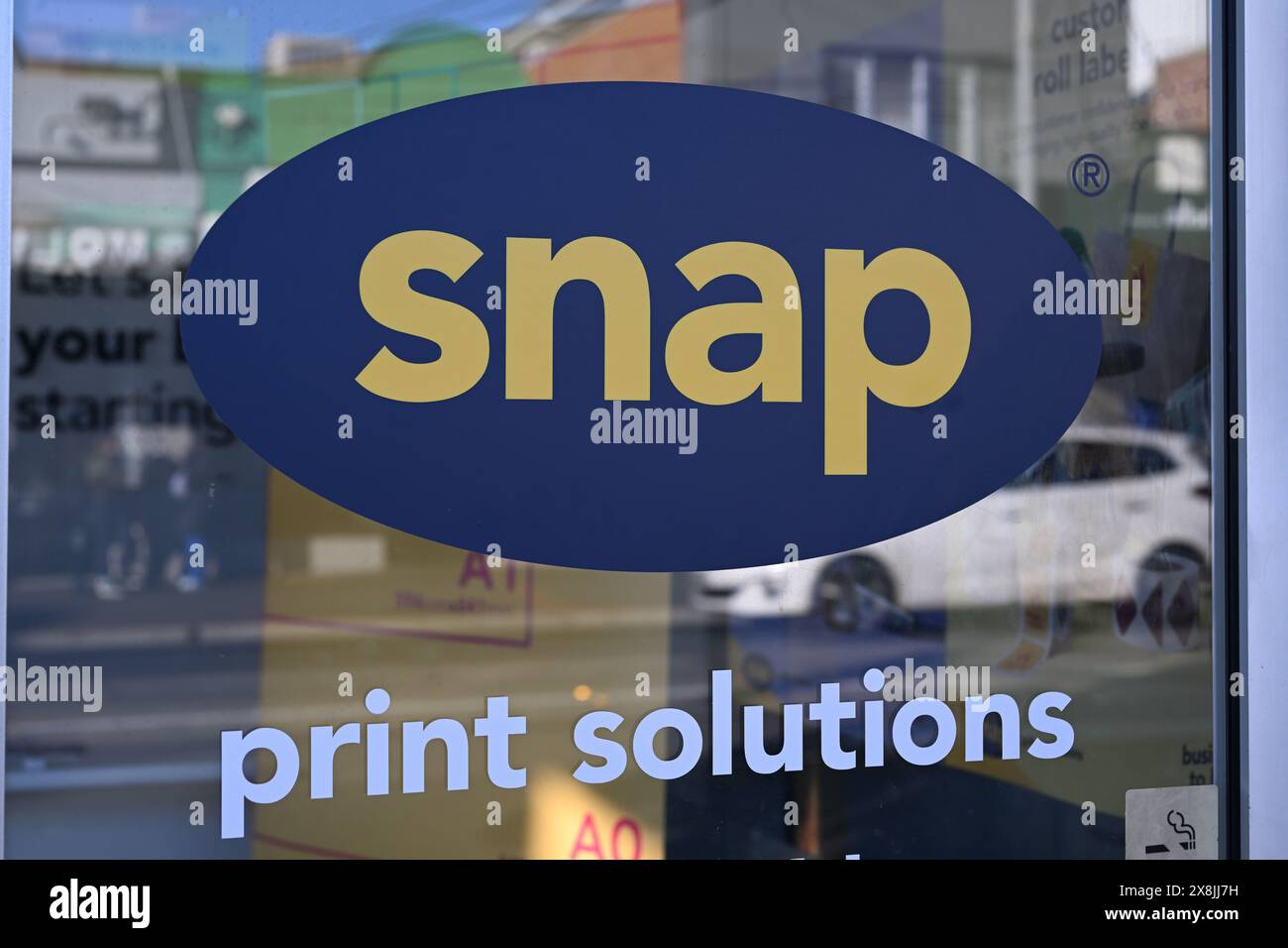 Blue and yellow Snap Print Solutions logo on the window of one of their ...
