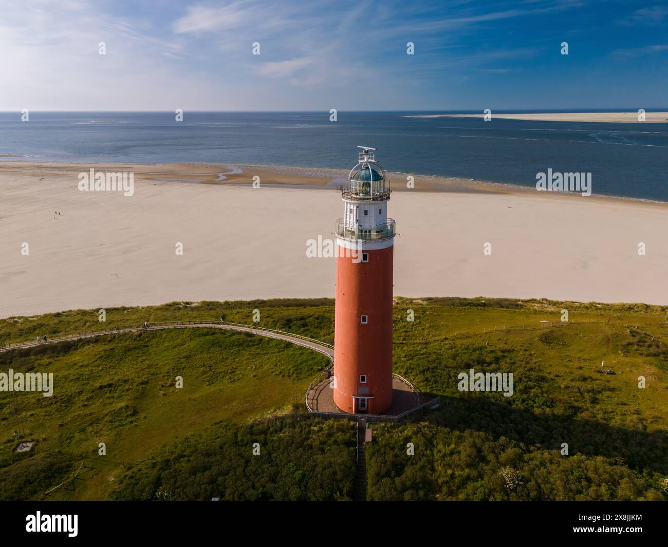Aerial perspective of a majestic lighthouse standing tall on a sandy ...