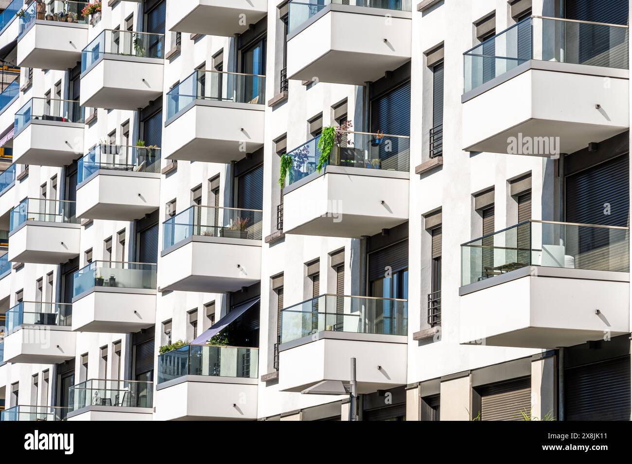 Facade of a white modern apartment building with small balconies seen ...