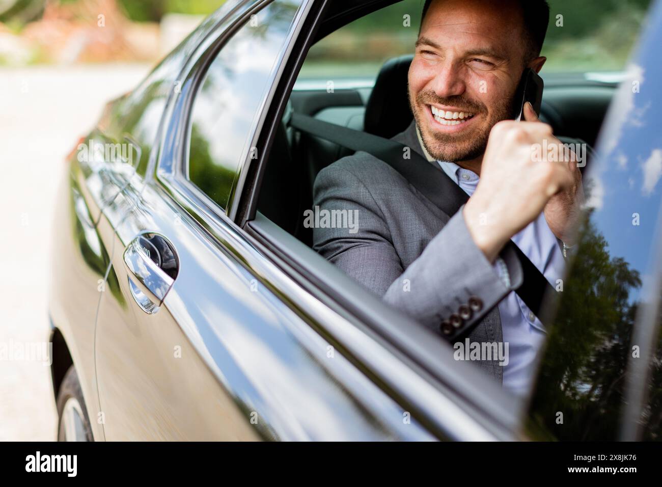 Man chuckles merrily during a car ride, enjoying a lively conversation ...