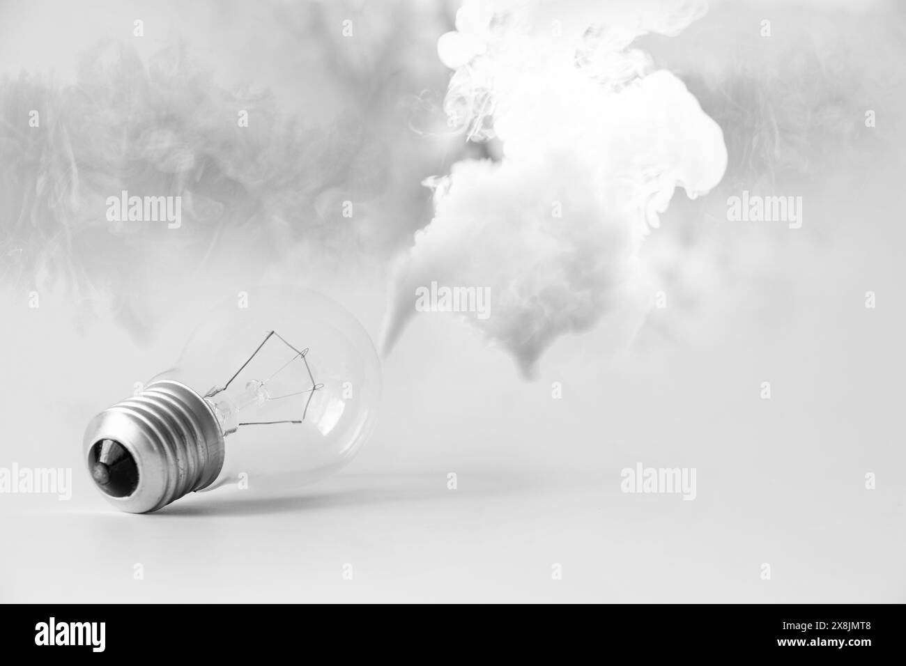 Incandescent light bulb and smoke on a white background, light and ...