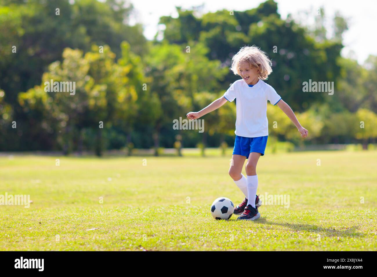 Kids play football on outdoor field. England team fan. Children score a ...