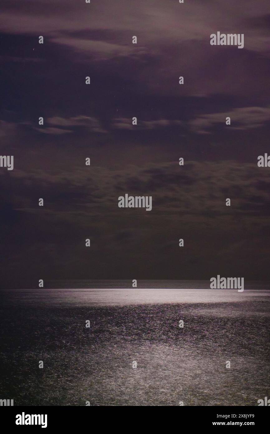 A night photograph of moonlight low in the sky above the Caribbean sea ...