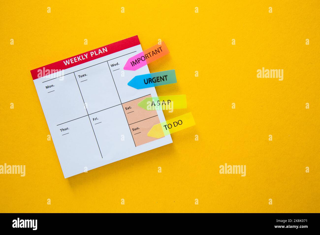 White weekly plan on a yellow background with bright colored sticky ...
