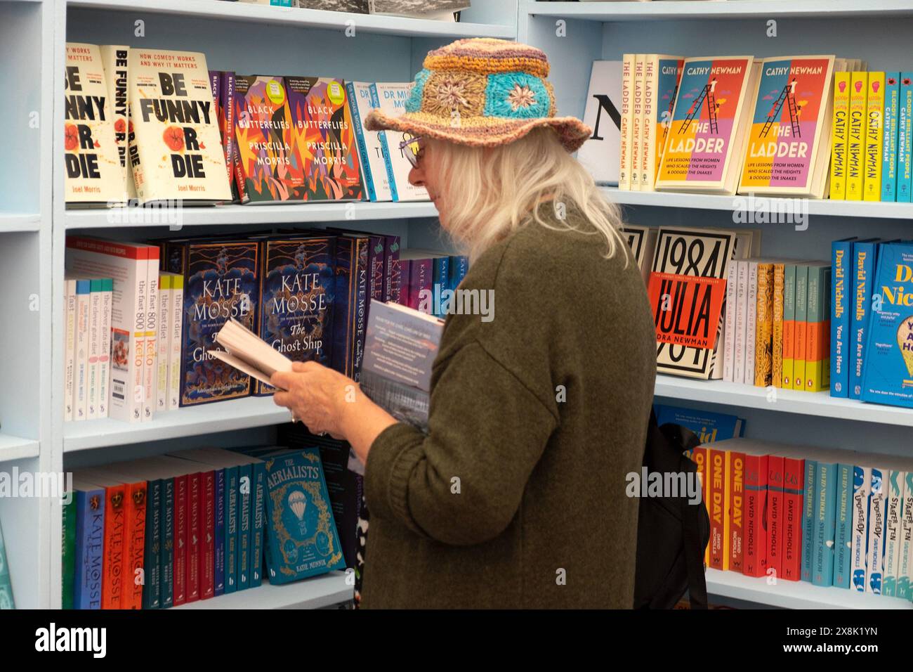 Person older woman straw hat reader reading looking at books for sale ...
