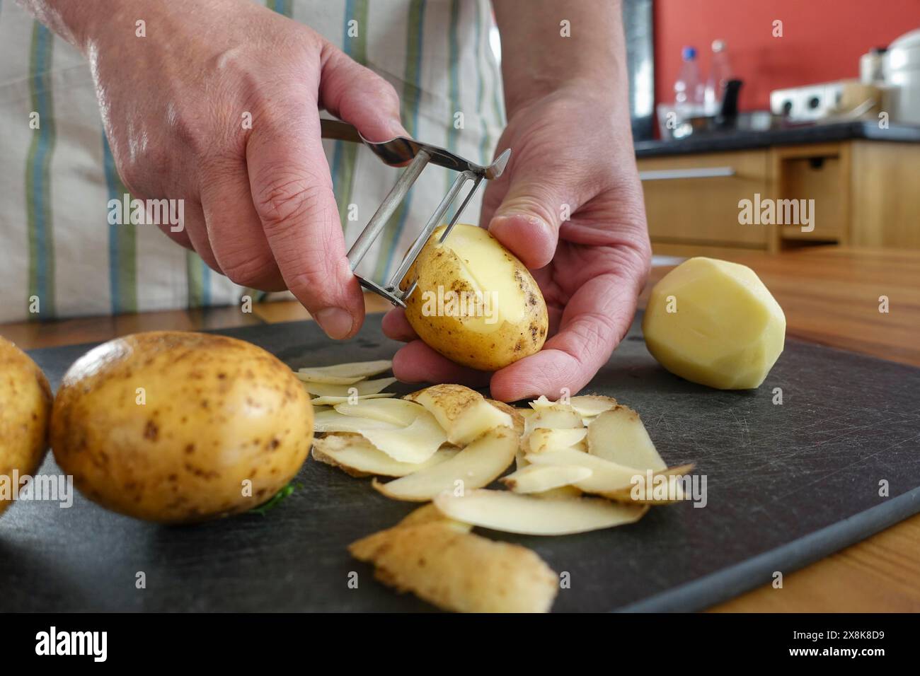 Swabian cuisine, preparation of potato salad, peeling raw potatoes ...