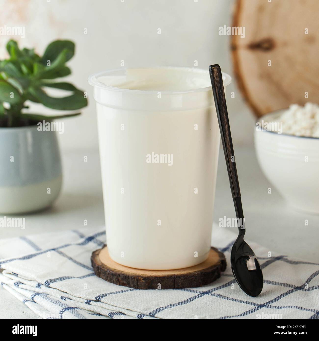 Natural sour cream in a plastic cup made from farm milk. Fermented milk ...