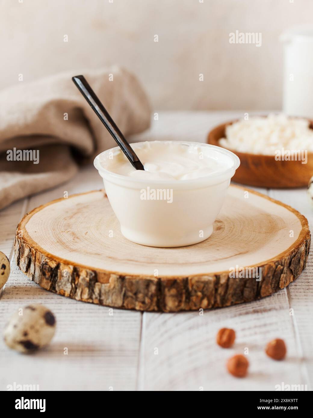 Natural sour cream in a plastic cup made from farm milk. Fermented milk ...